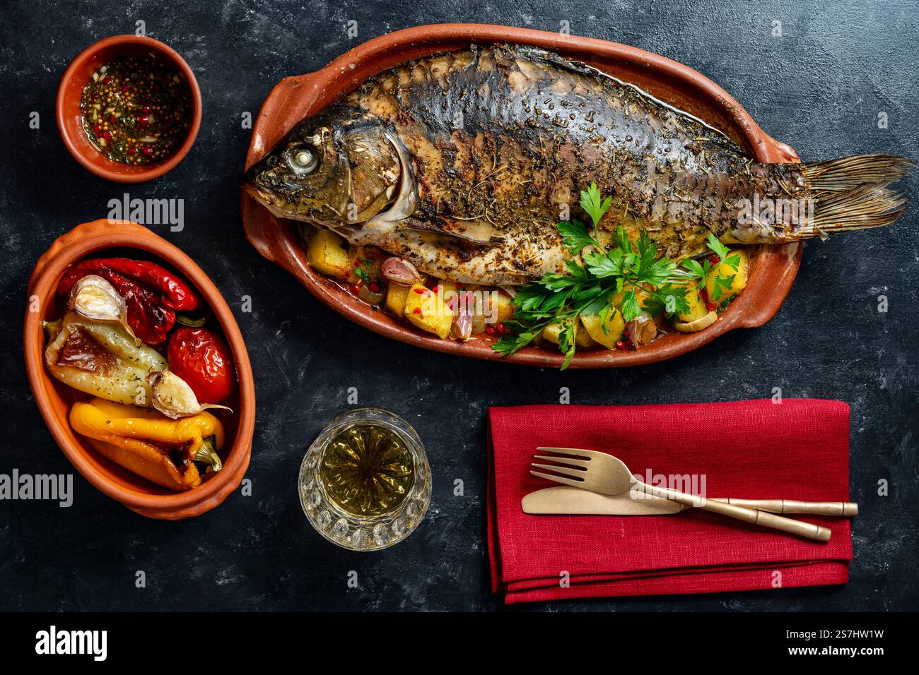Delicious baked carp fish with spices in a clay plate and fried ...