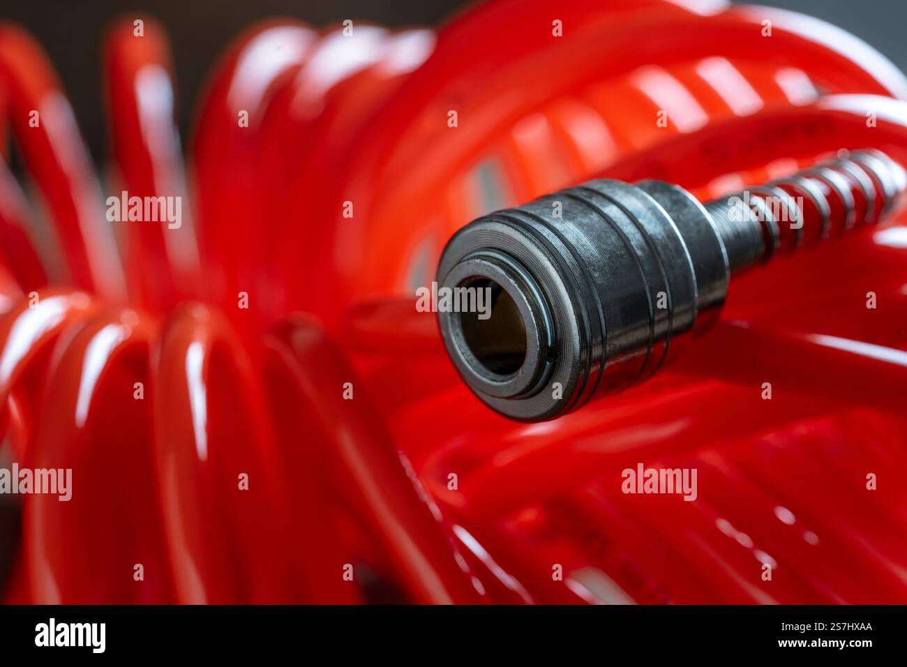 An orange air hose with an hose coupling , close up. Detail of air ...