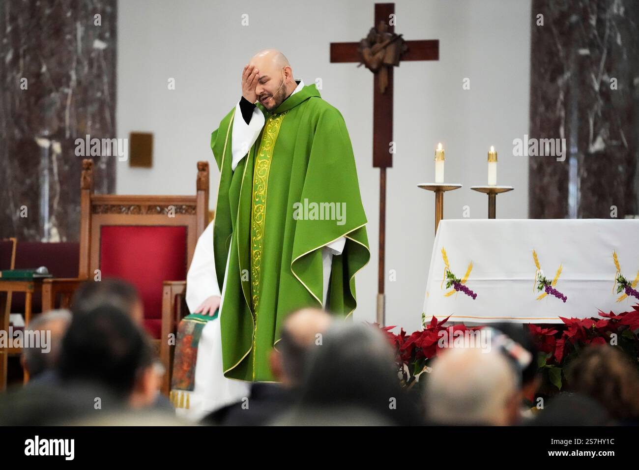Priest Homero Sanchez reacts as he speaks during a service at St. Rita ...