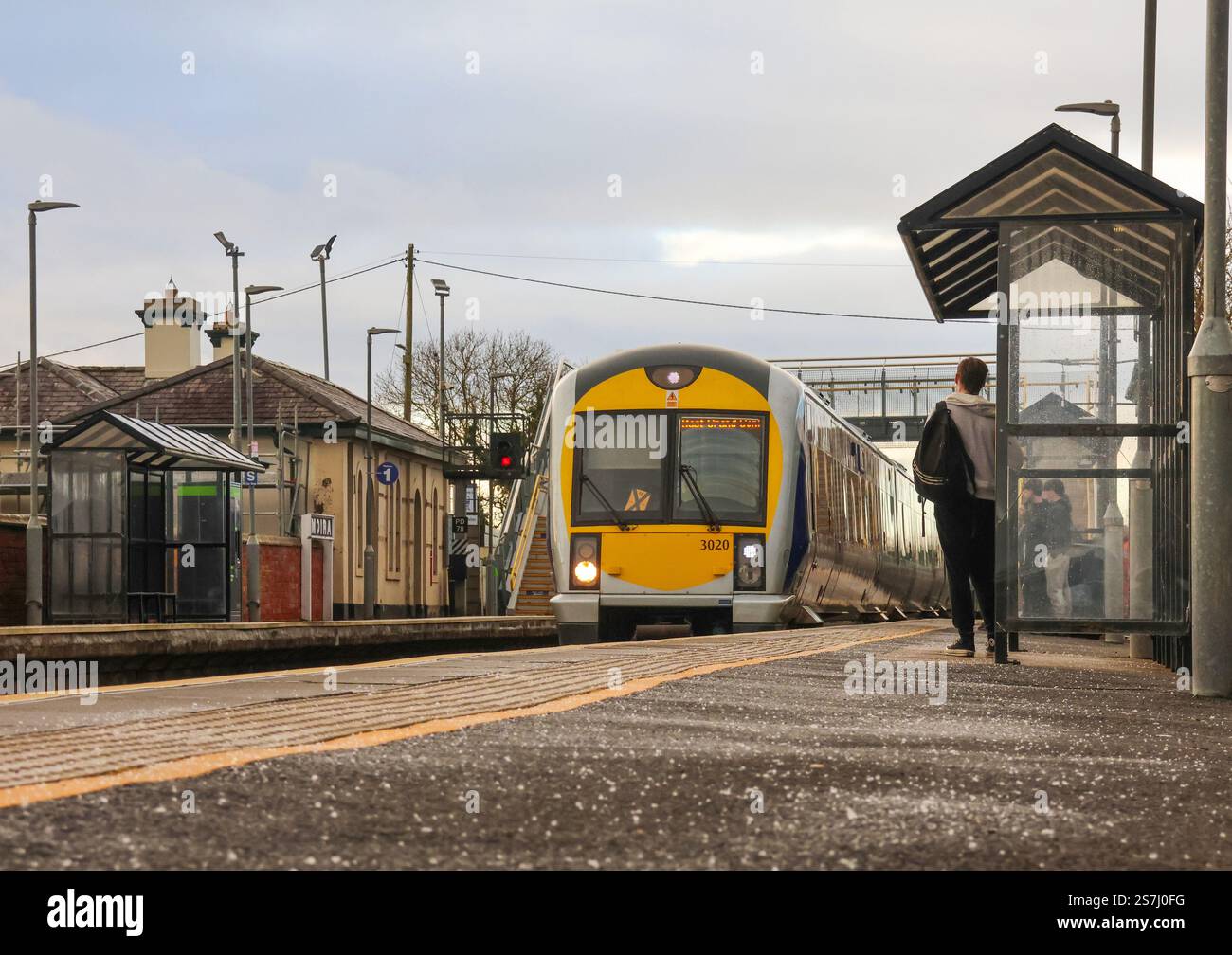 Diesel passenger CAF3000 train arriving at Northern Ireland Railways station plaform. Moira ...