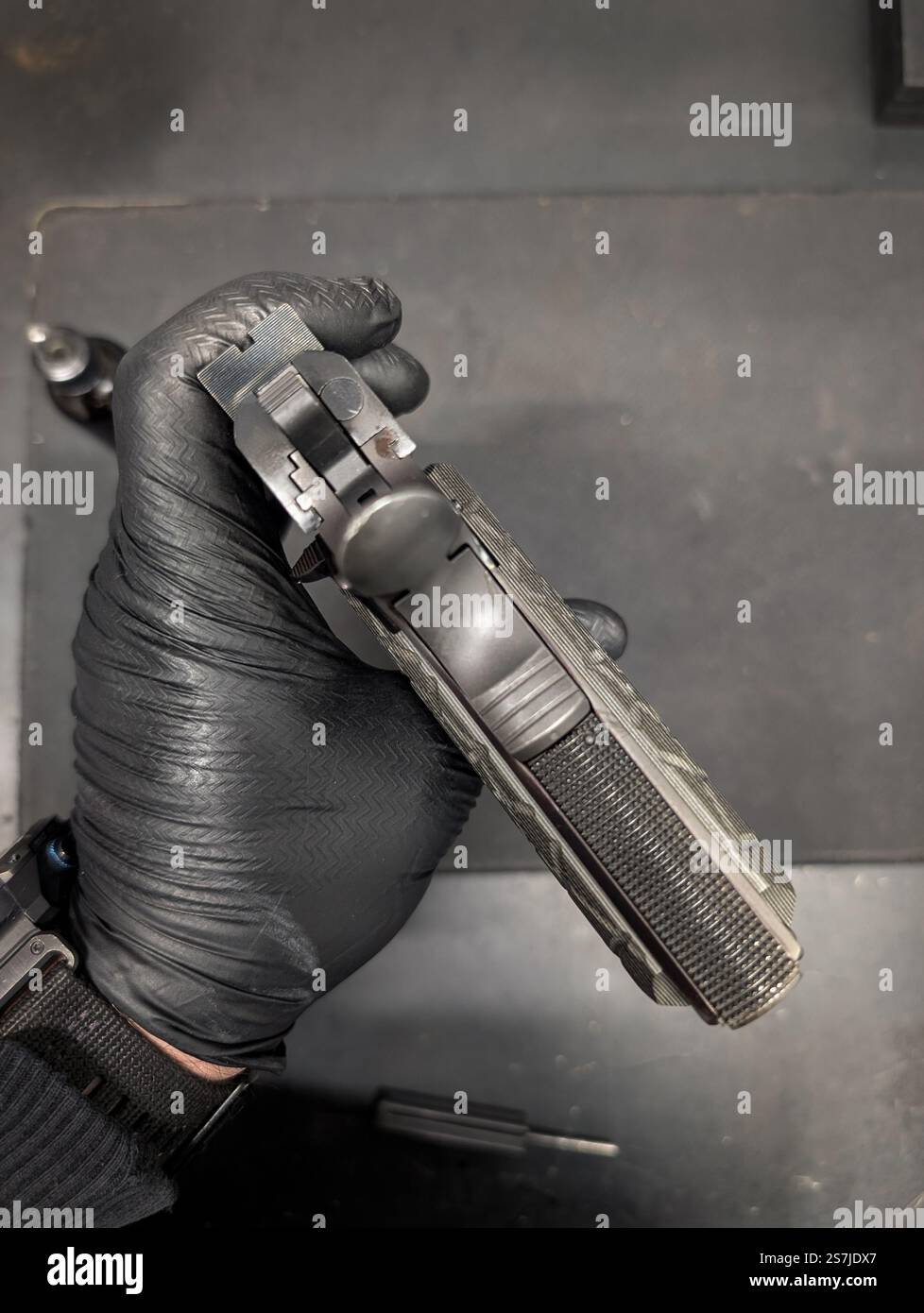 Pistol in the hand of a Gunsmith, vertical photo Stock Photo - Alamy