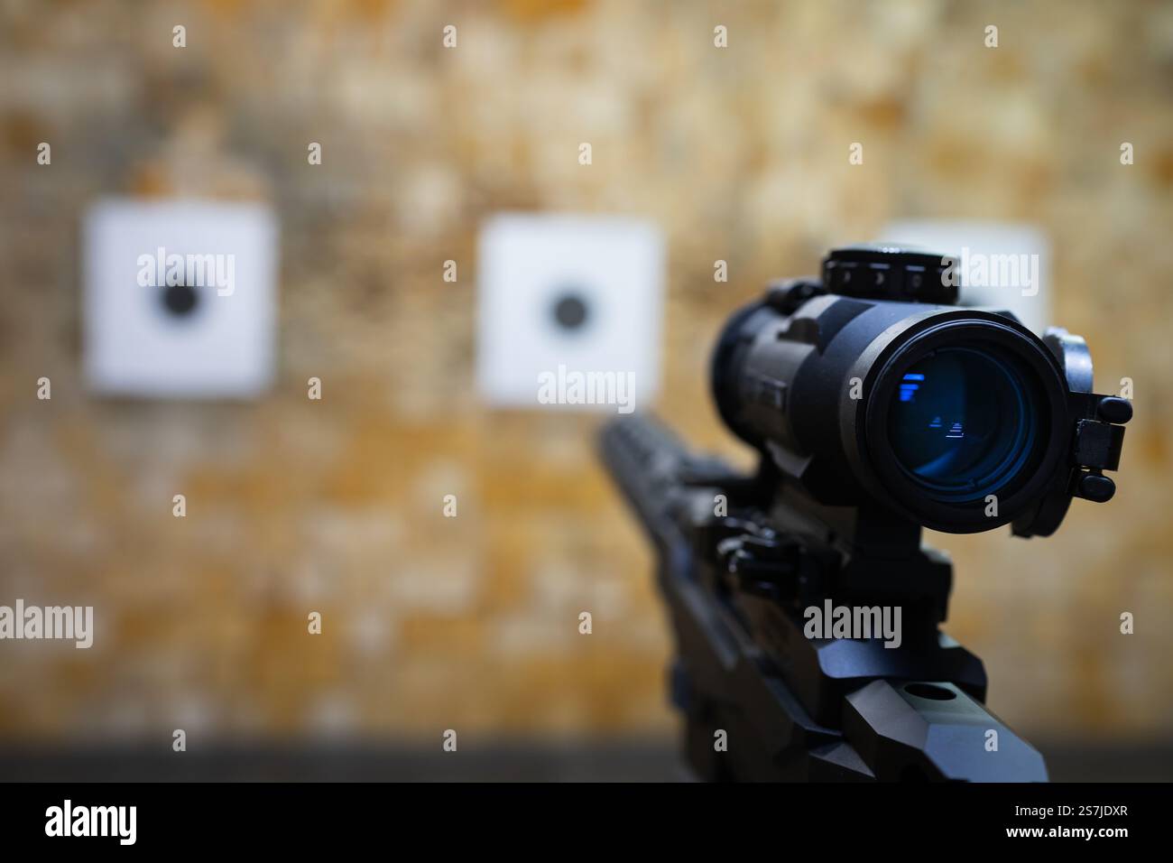 Modern pistol caliber rifle is aimed at the targets in a shooting range ...