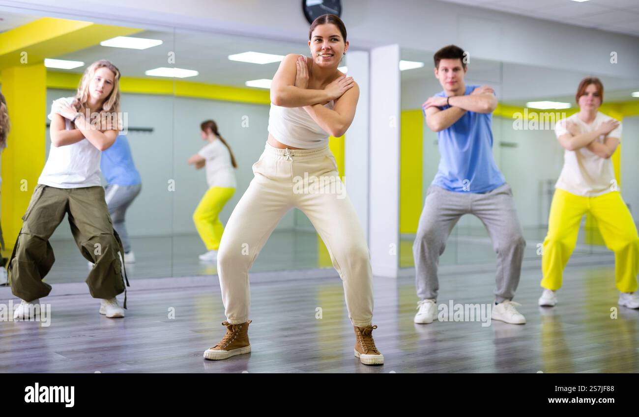 Group of active tween with crossed hands on chest during dancing lesson ...