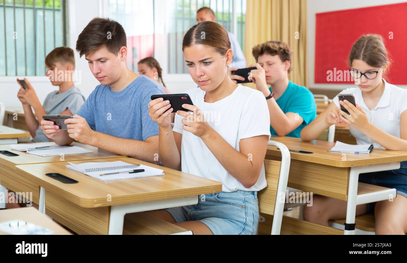 Classmates using their smartphones heavily during classes closeup Stock ...