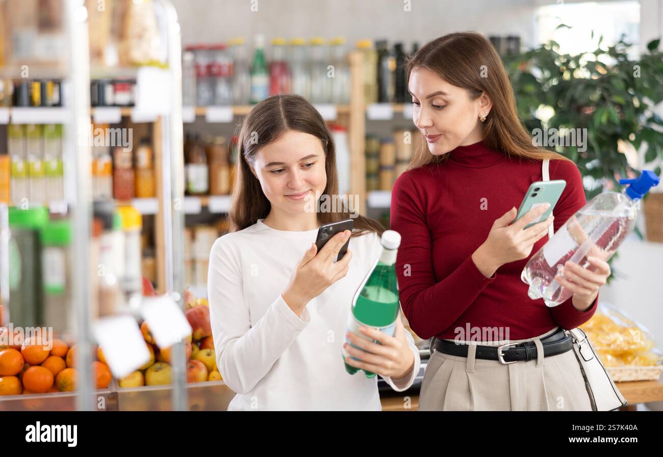 Mom and daughter scanning soda bottles Stock Photo - Alamy