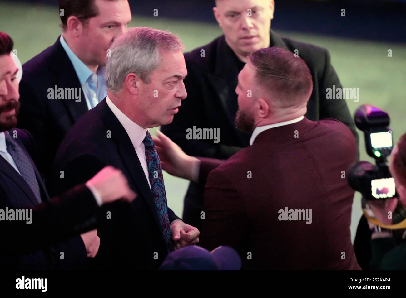 Reform UK leader Nigel Farage, left, speaks with Conor McGregor before ...