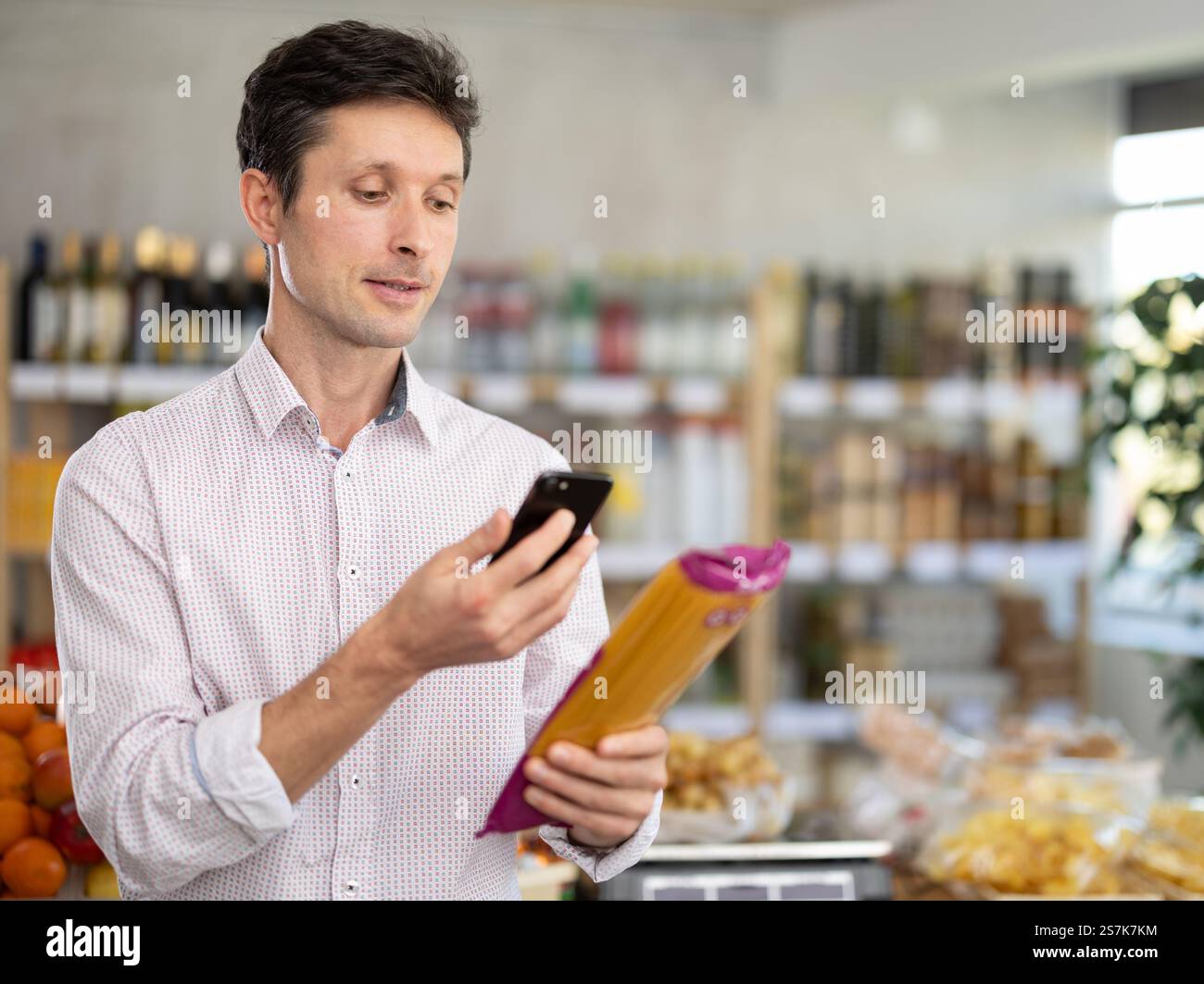 Adult man scanning qr code for pasta Stock Photo - Alamy
