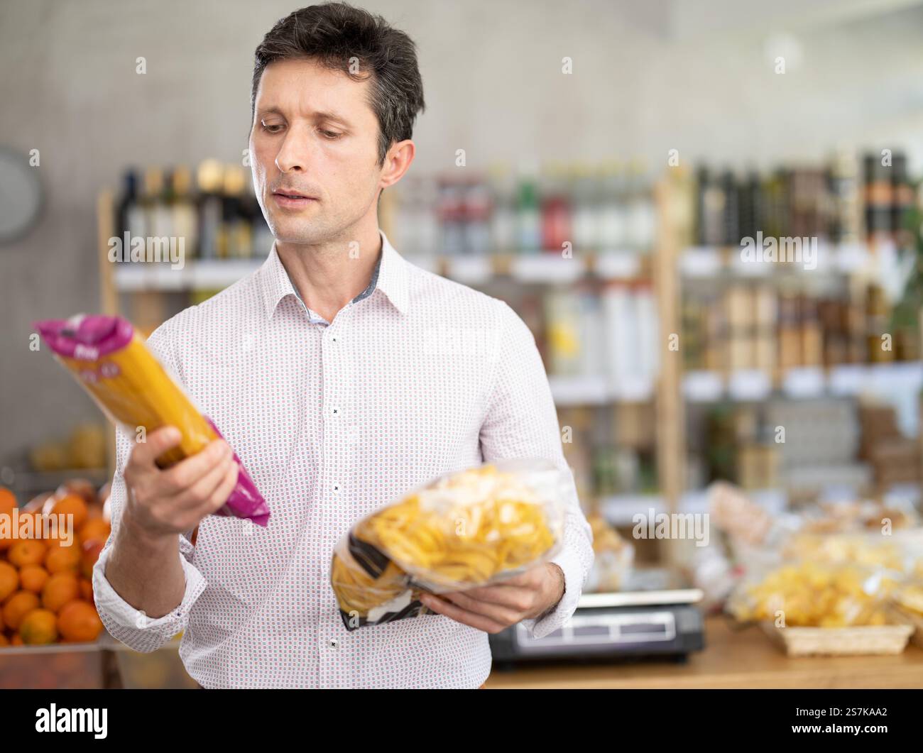 Adult man choosing pasta in grocery store Stock Photo - Alamy