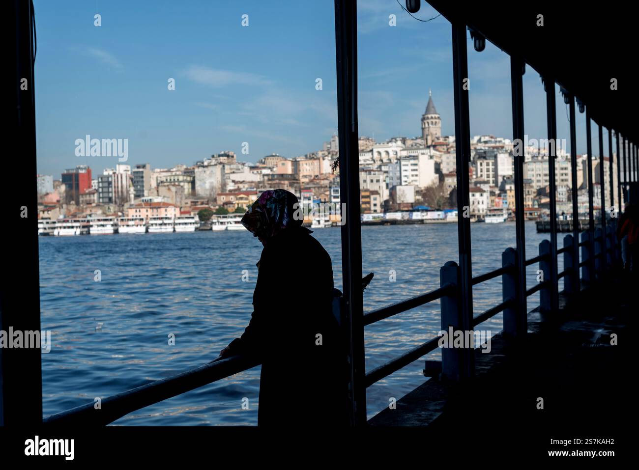 A Turkish Muslim woman on the Galata bridge that crosses the entrance ...