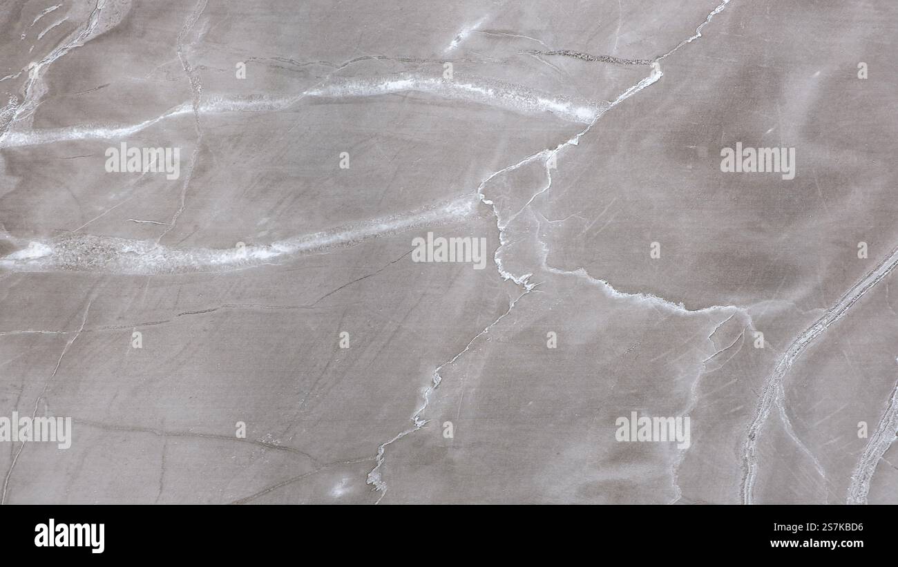 A grey stone with white lines on it. The stone is rough and has a lot ...