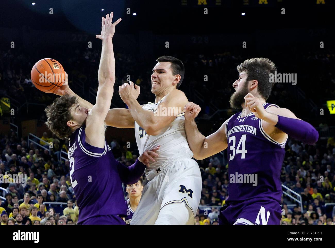 Michigan center Vladislav Goldin passes the ball against defenders ...