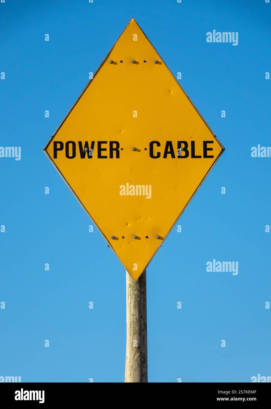 A Bright Yellow Warning Sign For A Power Cable Stock Photo - Alamy