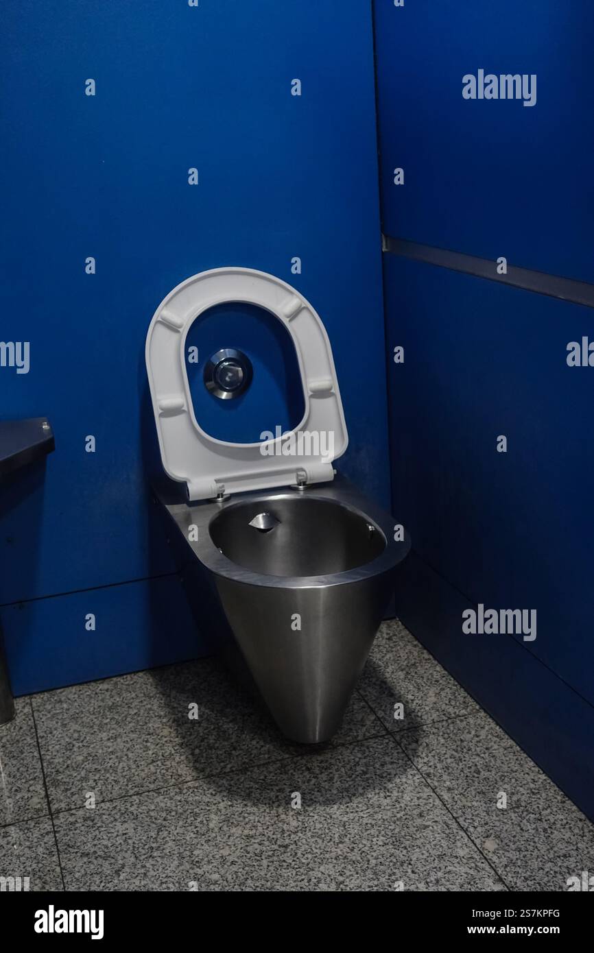 A stainless steel toilet located inside a blue stall Stock Photo - Alamy