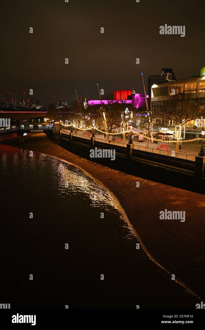 Illuminated City Riverfront at Night with Reflections and Festive ...