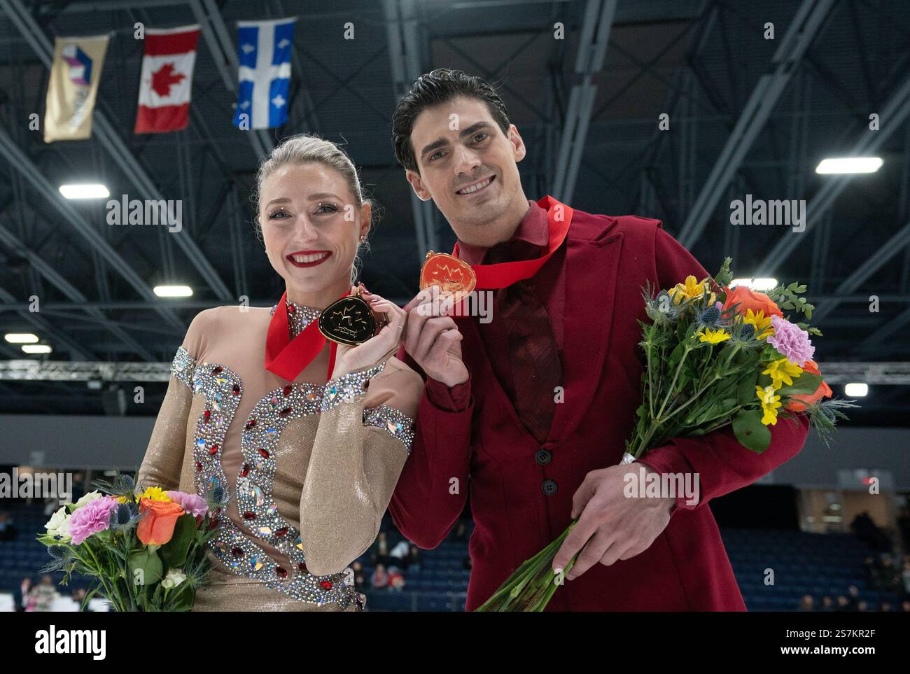 Gold medalists Piper Gilles and Paul Poirier hold up their medals ...