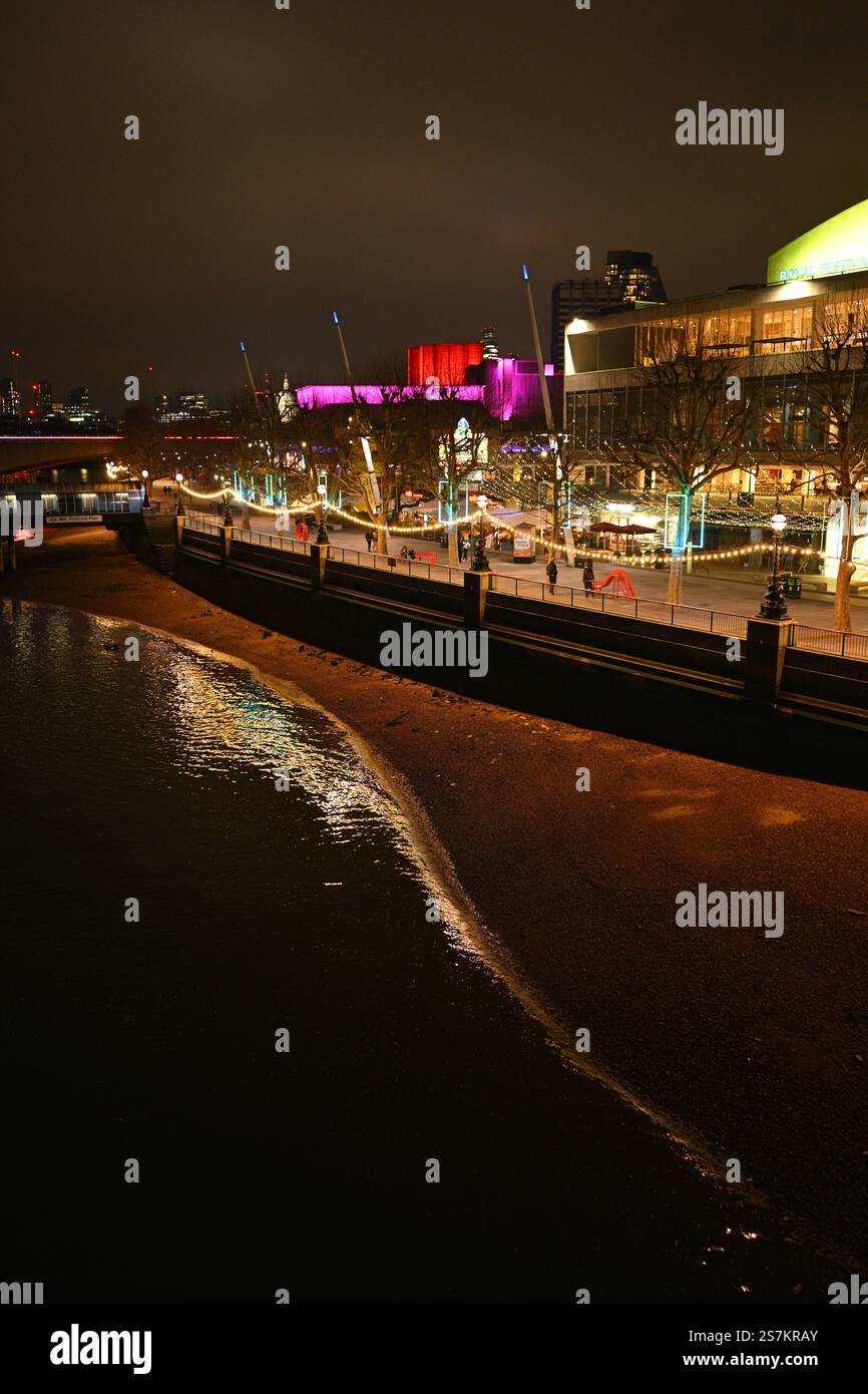 Illuminated City Riverfront at Night with Reflections and Festive ...