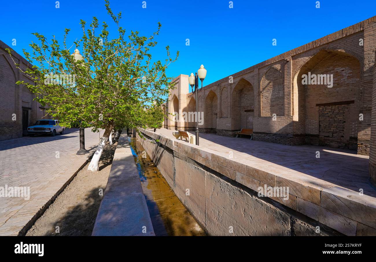Canal passing by the Khoja Gaukushan Mosque in Bukhara, Uzbekistan ...