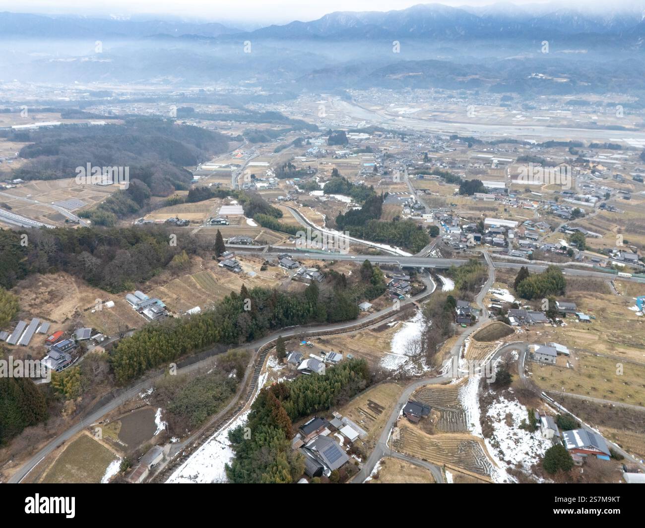 Aerial shot of snow-covered winter landscape of Iida City, Nagano ...