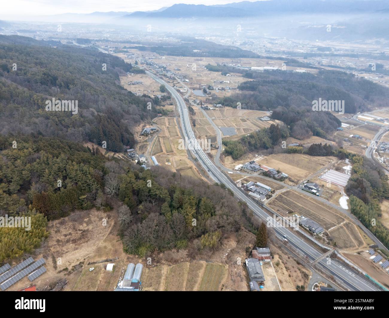 Aerial shot of snow-covered winter landscape of Iida City, Nagano Prefecture using drone Stock ...