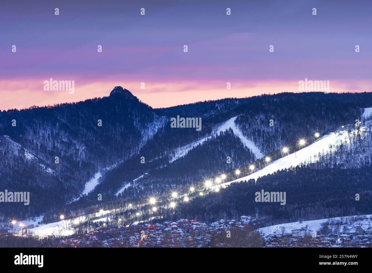 A stunning night view of a ski resort, illuminated by bright lights ...
