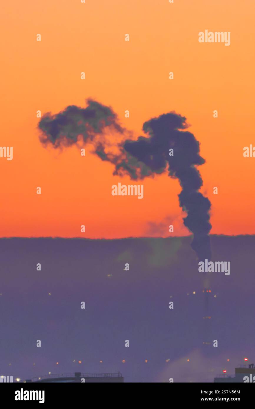 A breathtaking view of smoke rising into a colorful sunset sky ...