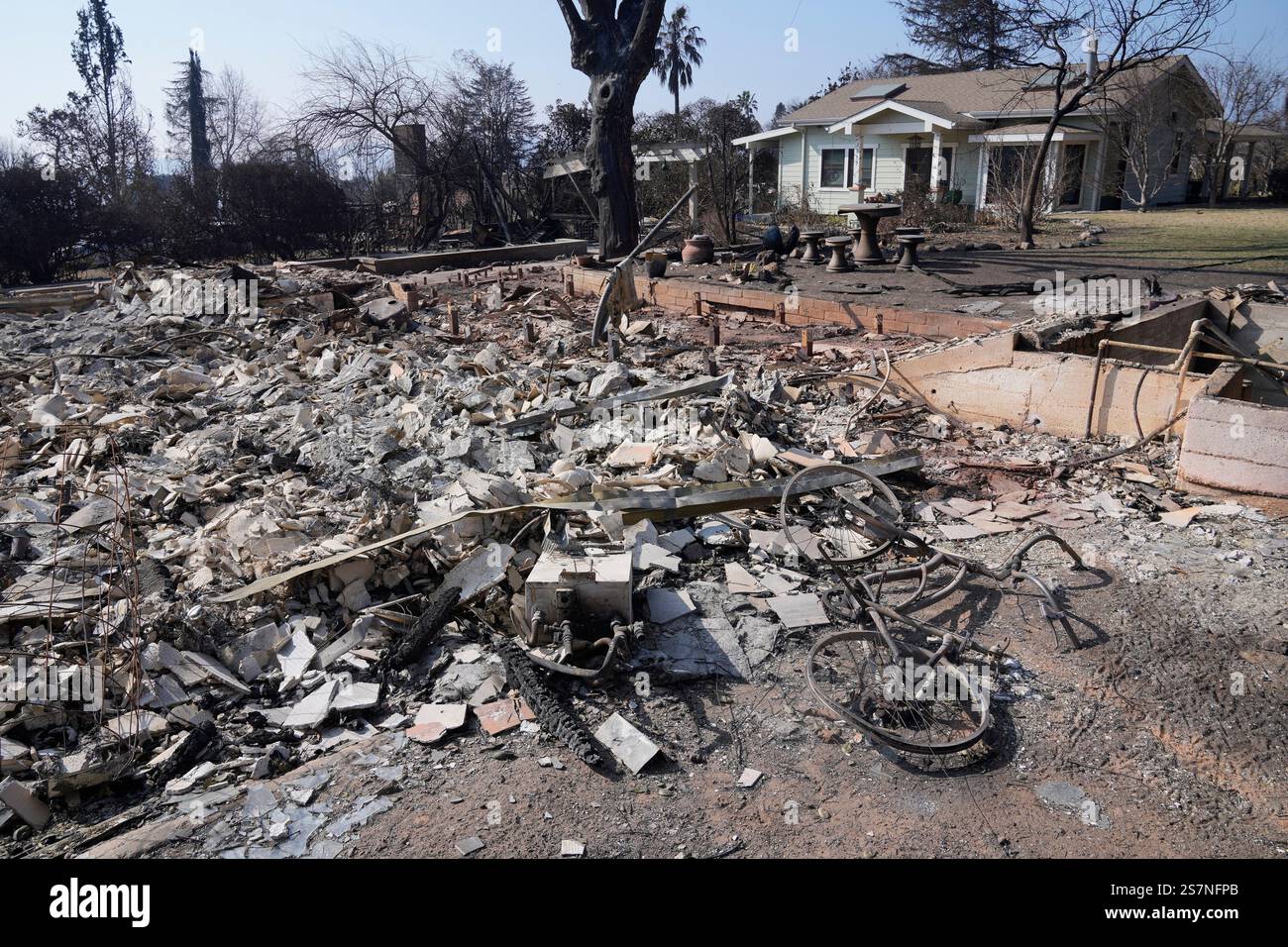 Debris from a destroyed home is seen as a newly built ADU (accessory ...