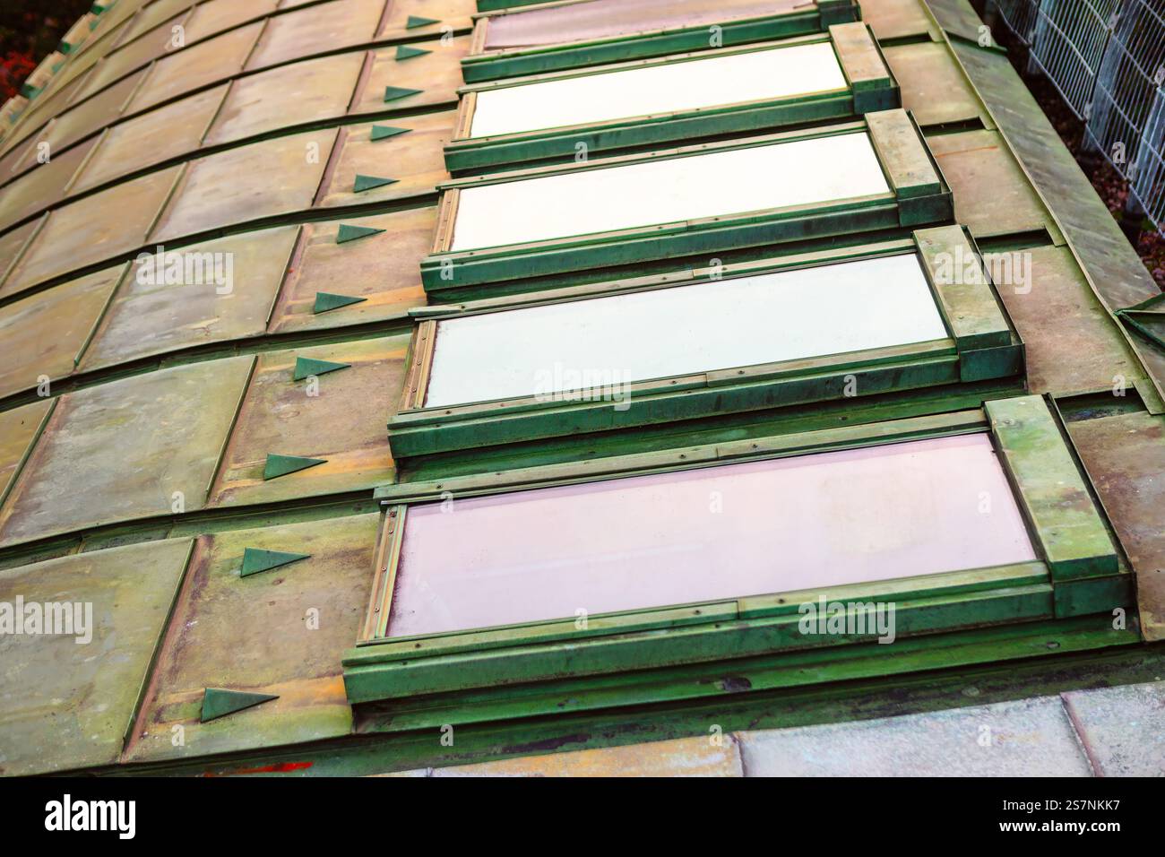 Rectangular skylights framed in metal are neatly arranged in two ...