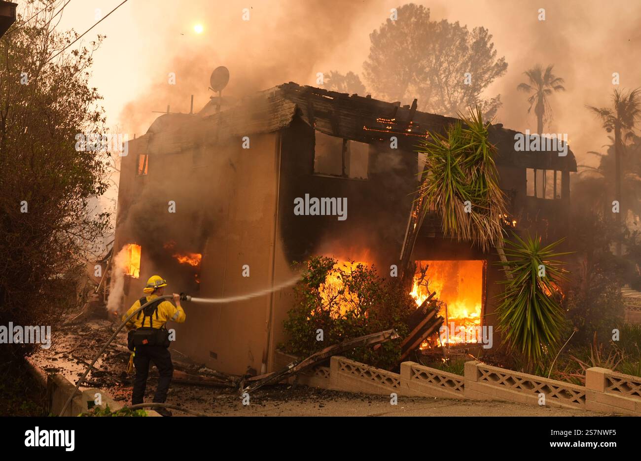 A firefighter tries to extinguish flames at a burning apartment ...