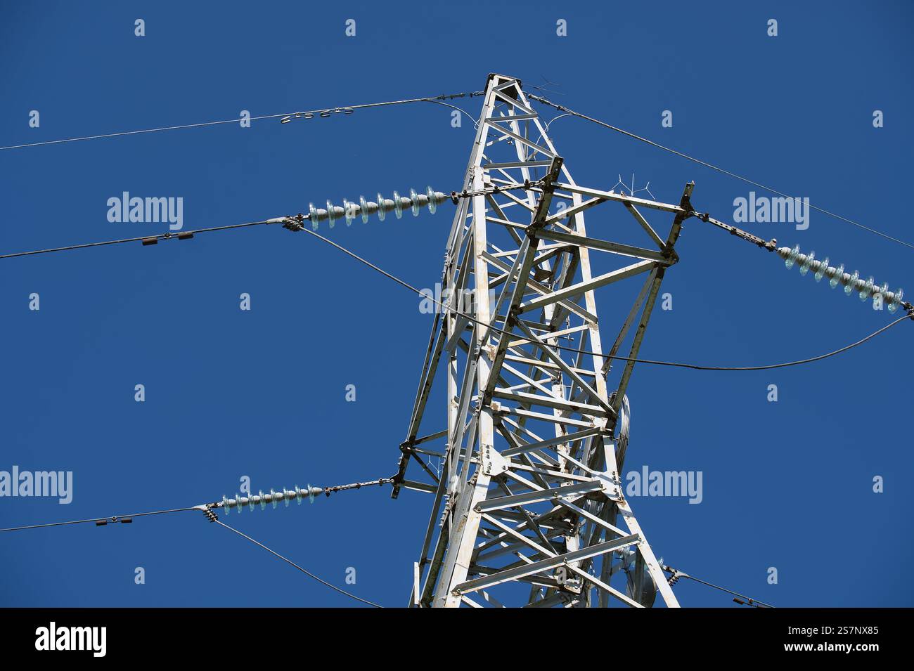 Metal electricity pylon transporting energy through cables with glass ...
