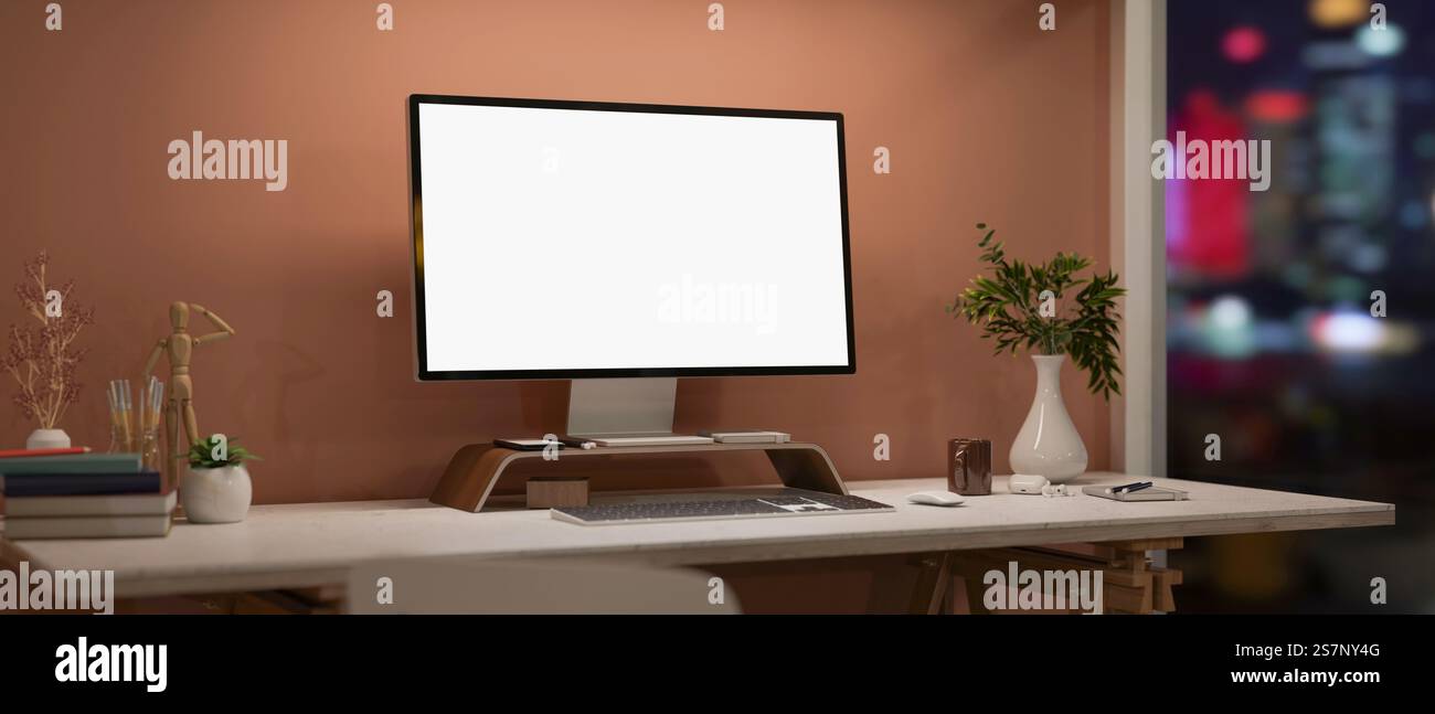 A computer with a white screen mockup and decorative items on a white ...
