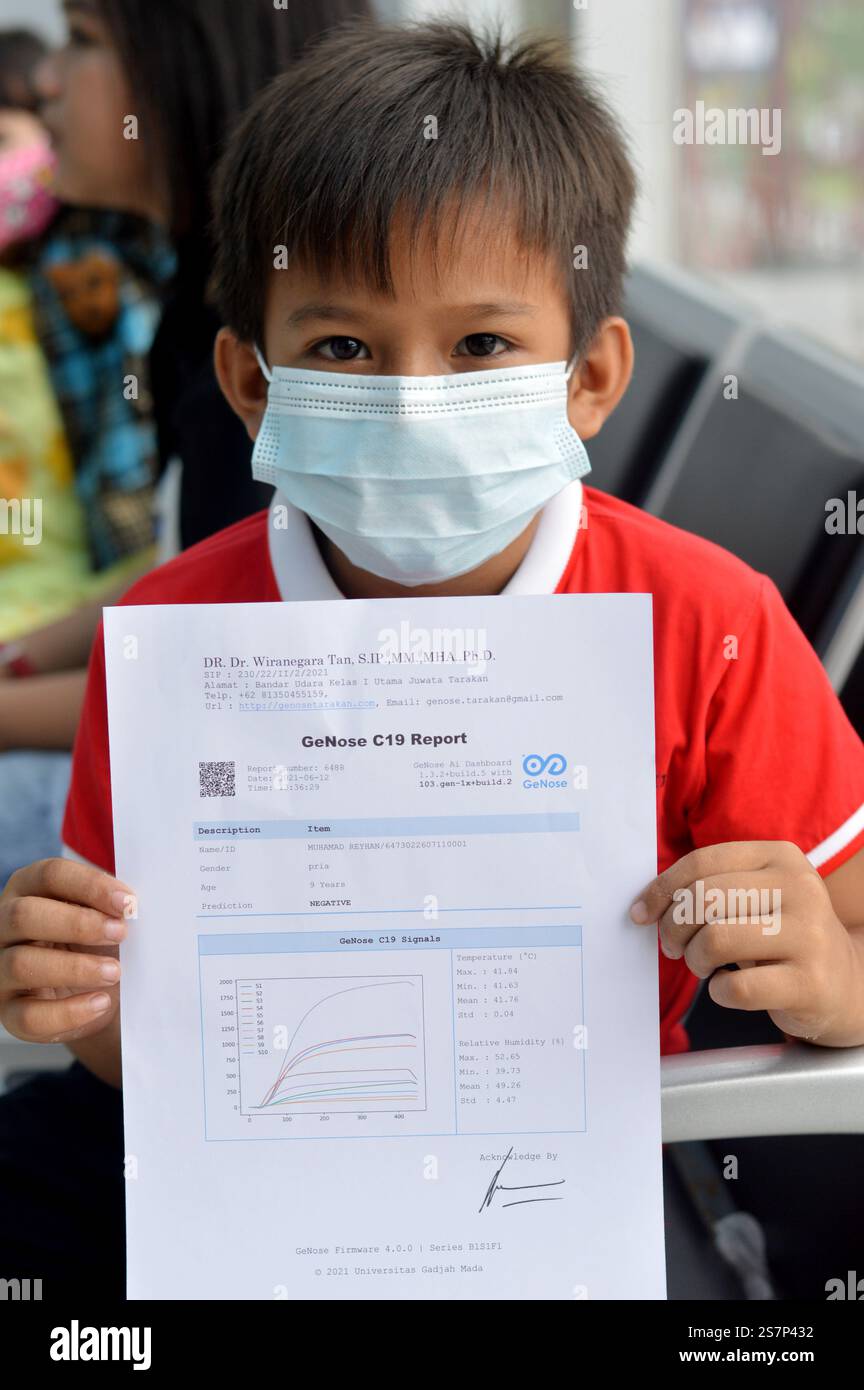 TARAKAN - INDONESIA,12 JUNE 2021 : a boy shows a negative certificate ...