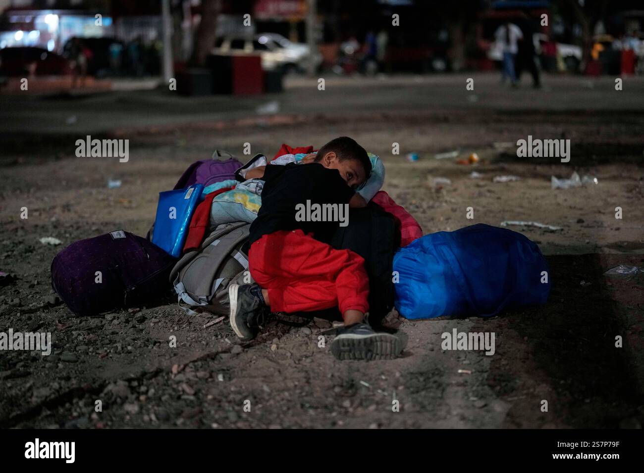 A boy rests outside a soccer stadium in Cucuta, Colombia, where people ...