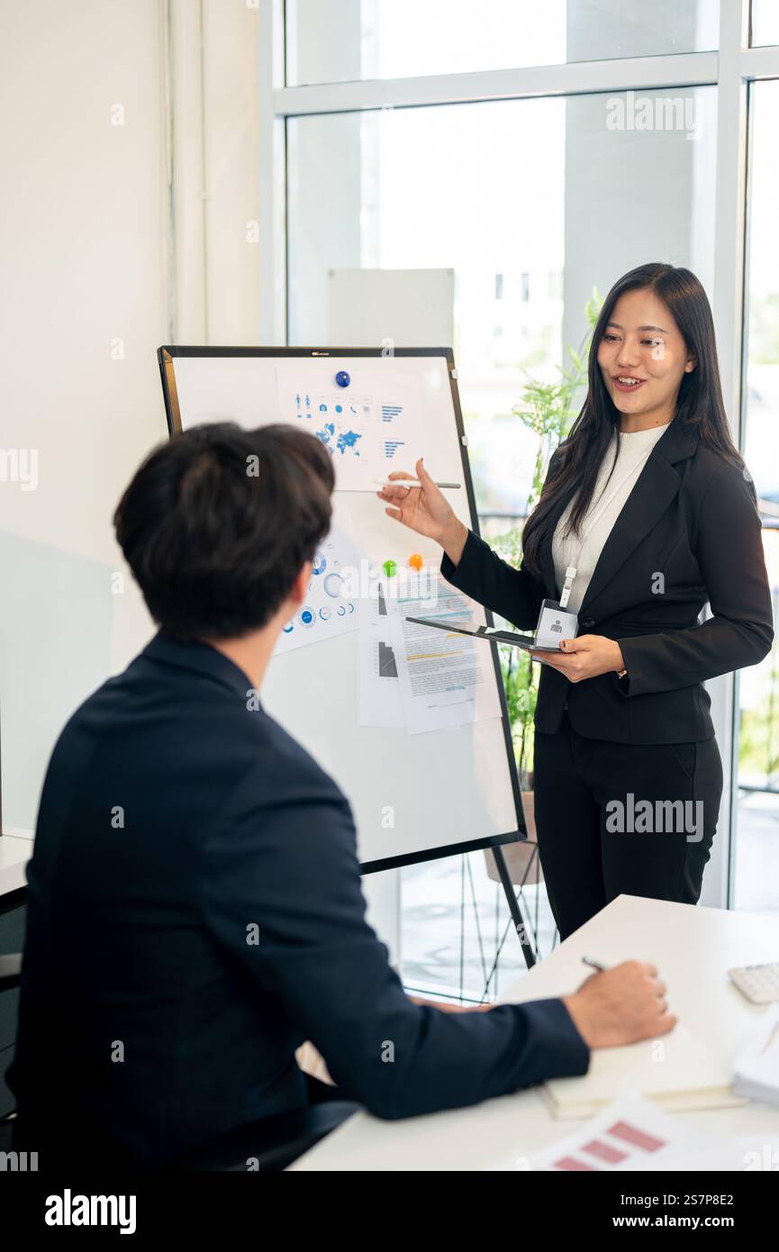 A confident, positive Asian businesswoman is presenting her project to ...