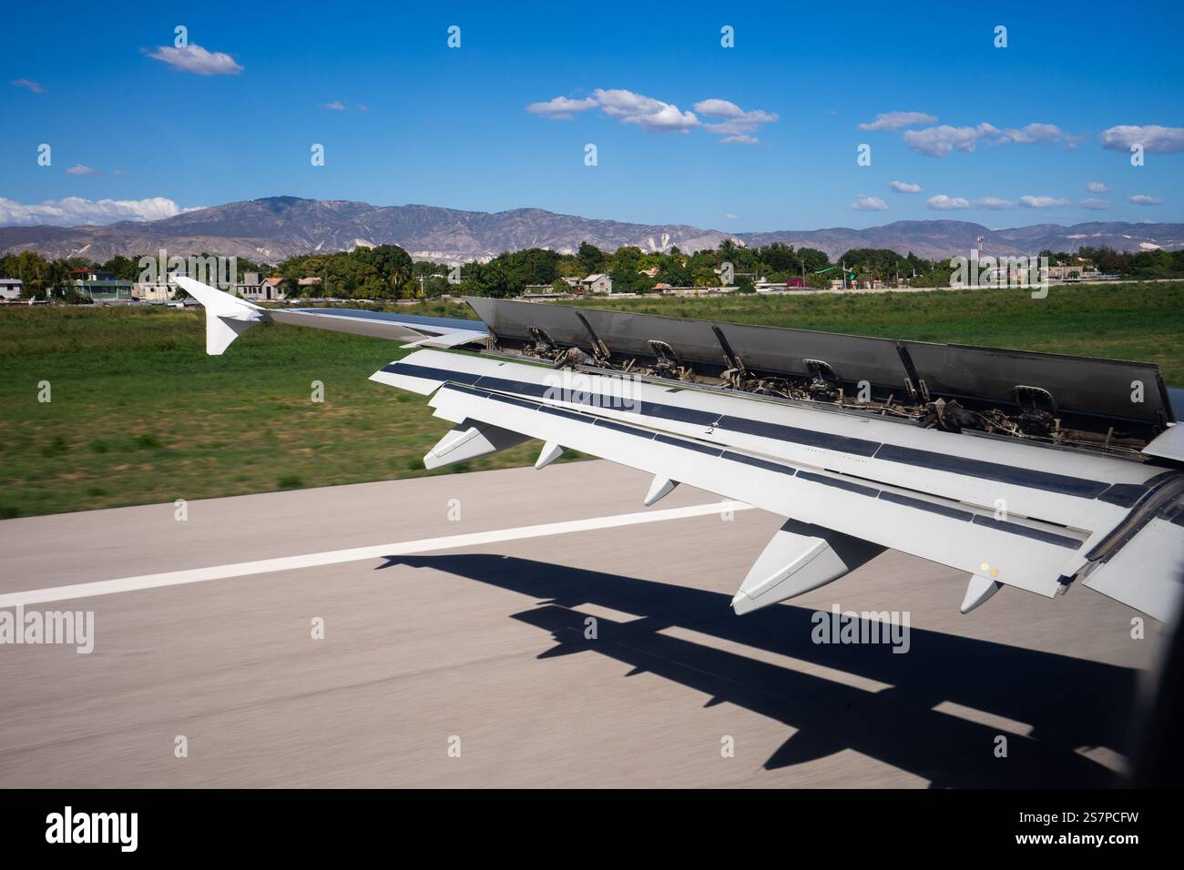 Close-up of an airplane wing with spoilers deployed, showcasing the ...