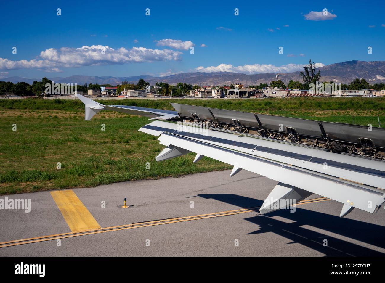 Close-up of an airplane wing with spoilers deployed, showcasing the ...