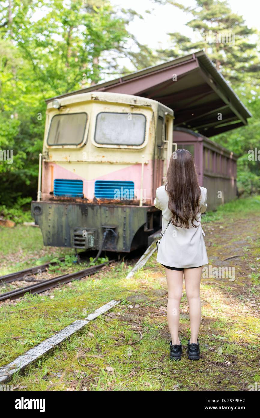 A Japanese woman in her 20s wearing white clothes spends her time on an ...