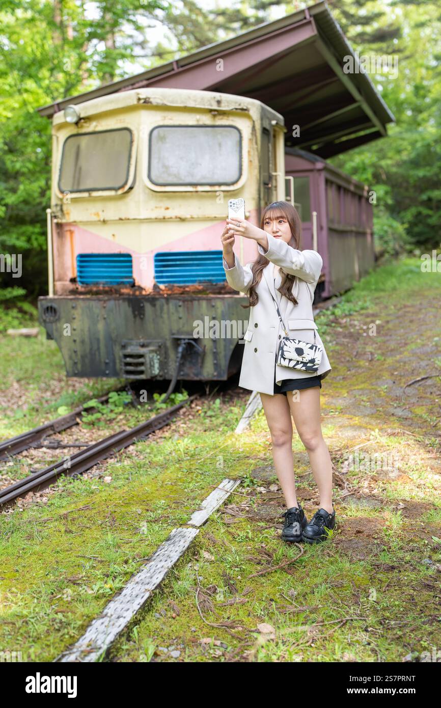 A Japanese woman in her 20s wearing white clothes spends her time on an ...