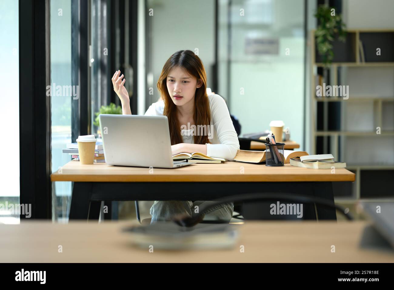 Concentrated college student tackling online learning, working on her ...