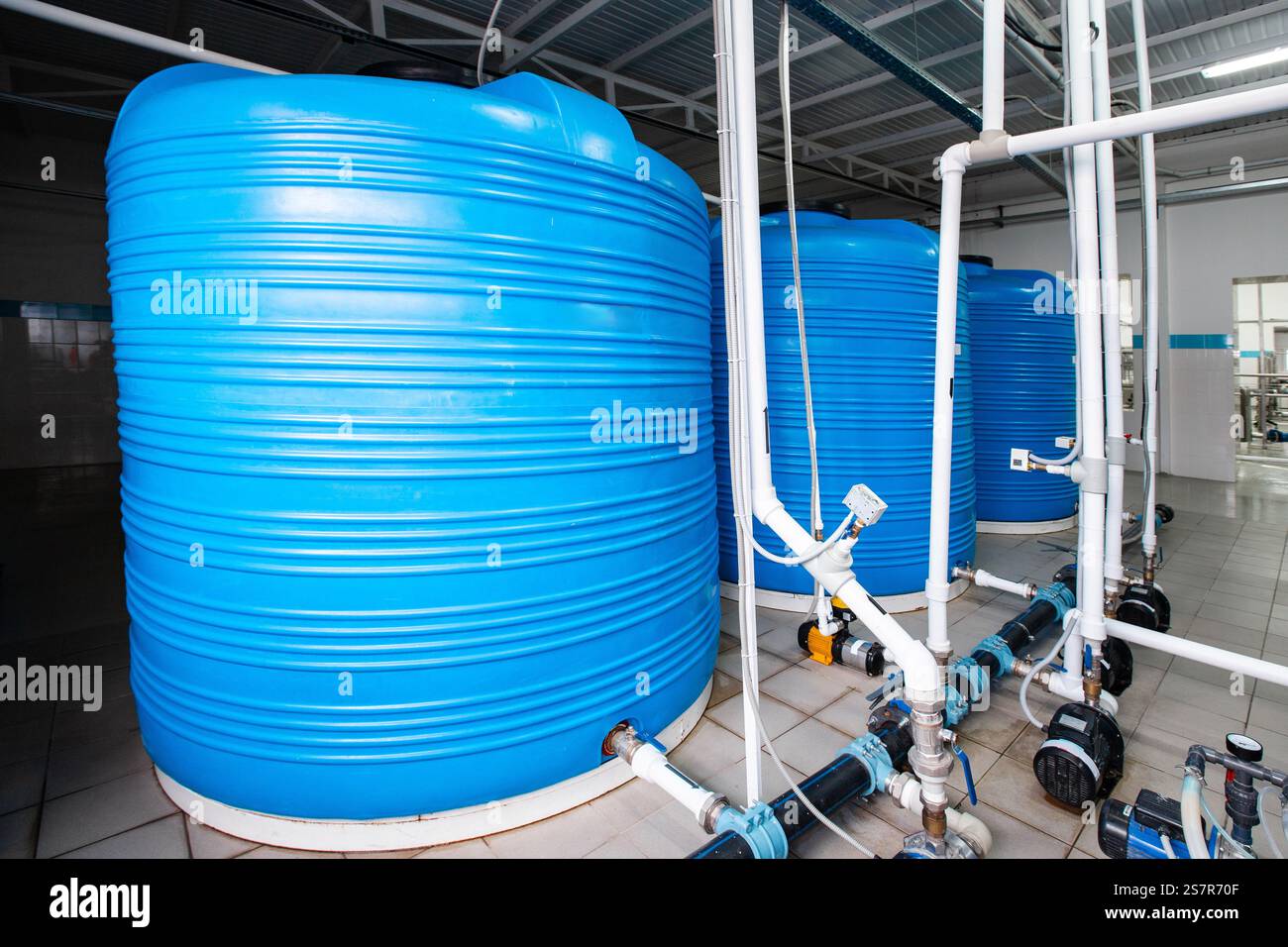 Large blue water storage tanks arranged systematically in a modern ...