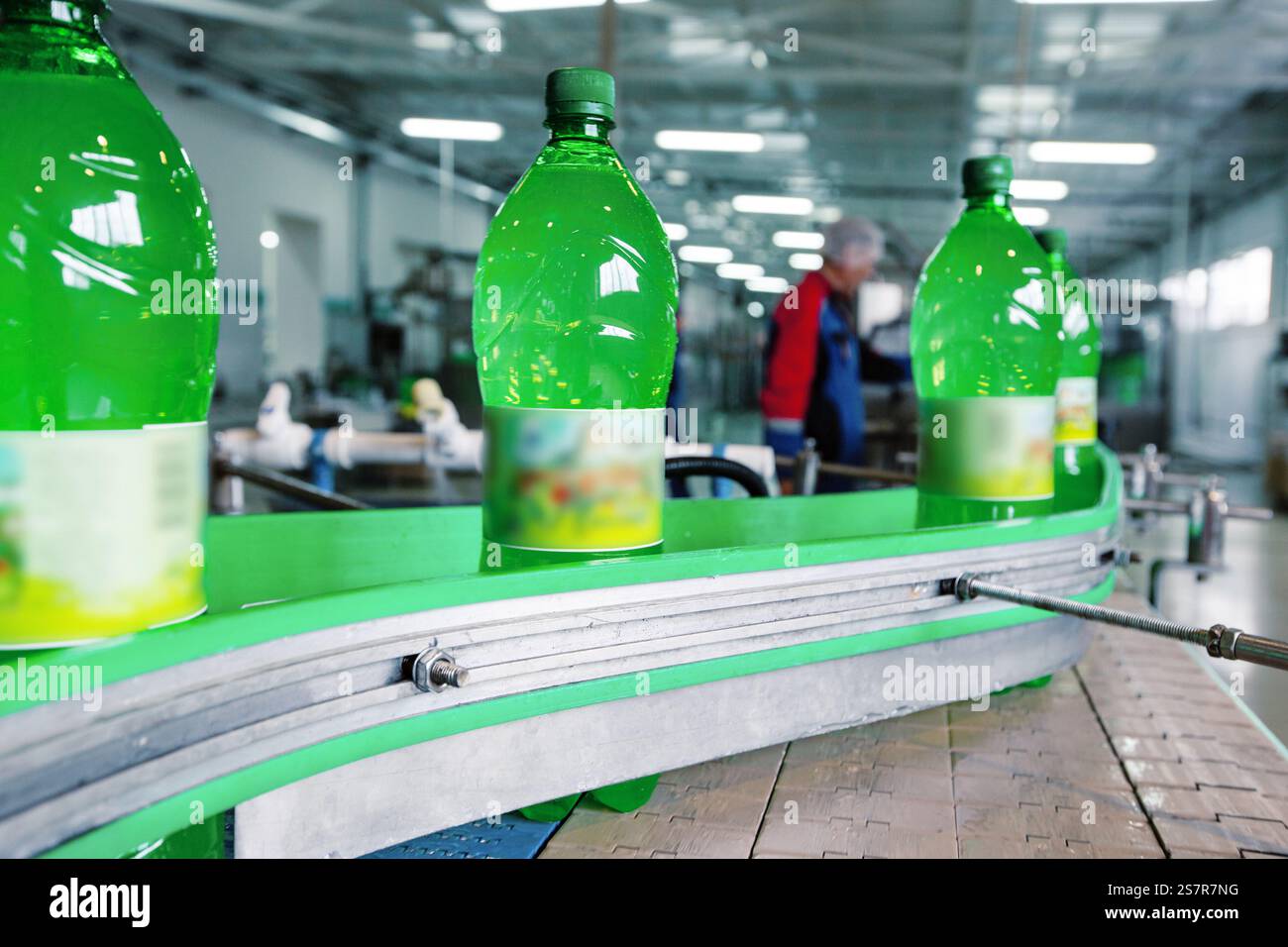 Bottling process of soft drinks in a factory during daytime with green ...