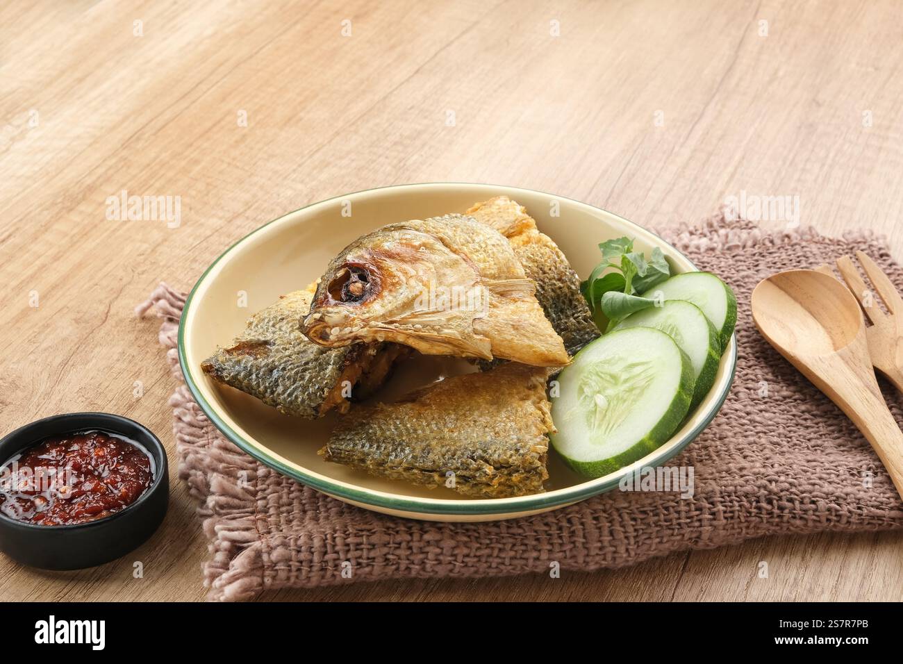 Bebek Goreng Kremes, served with chili sauce (sambal) and cucumber ...