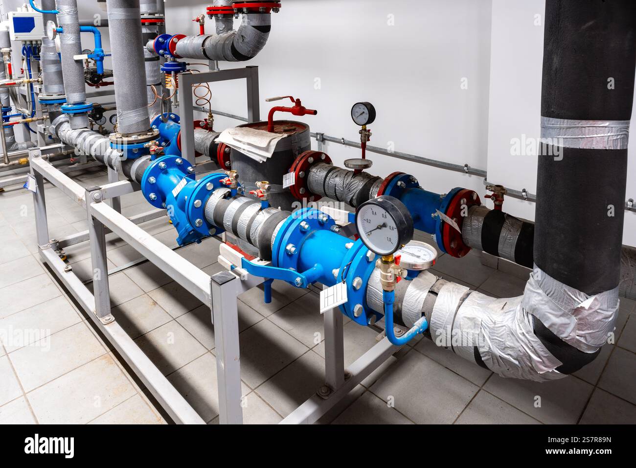 Industrial piping system showing blue and gray pipes and measuring ...