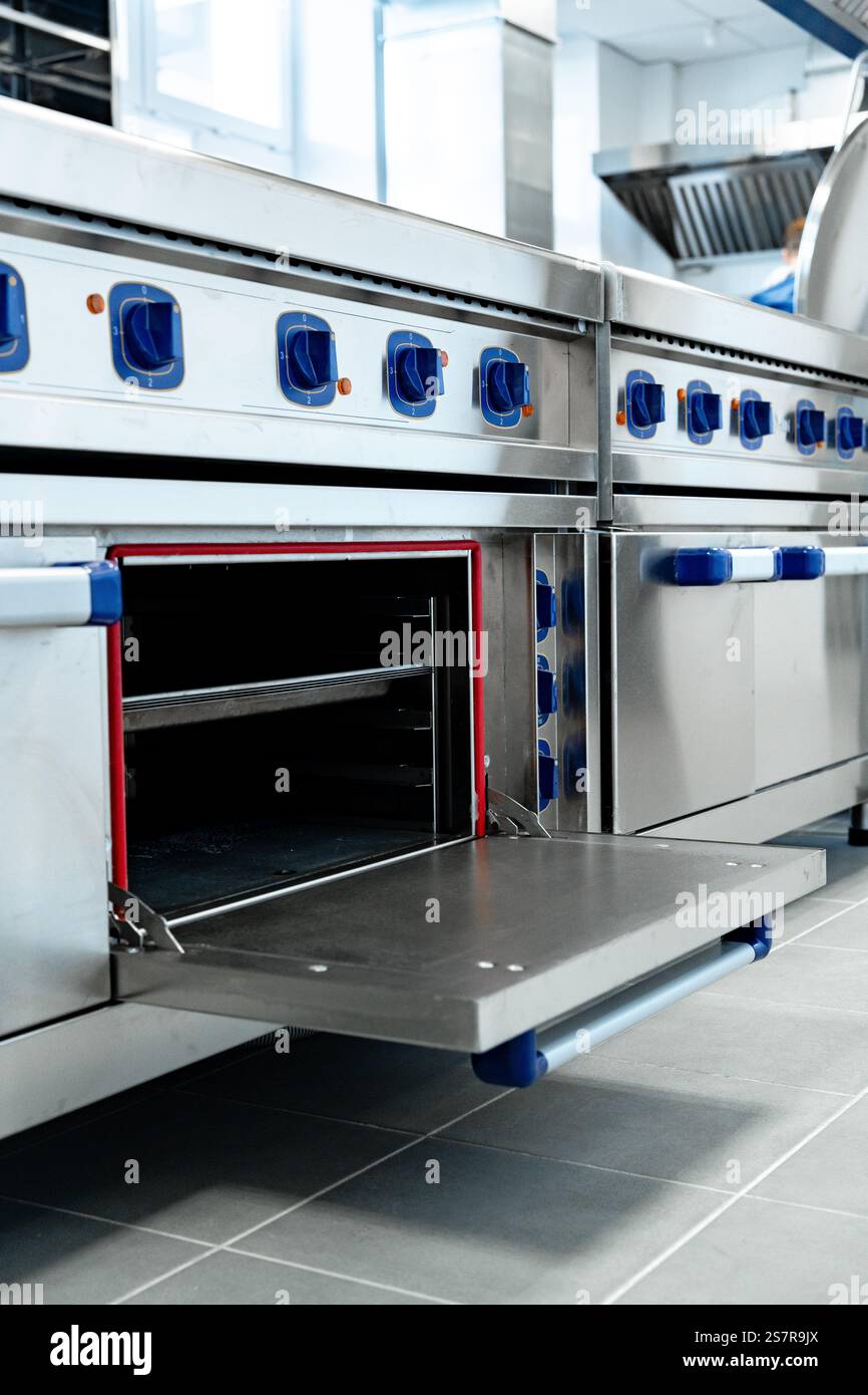 Industrial kitchen with stainless steel appliances and a baking oven in ...