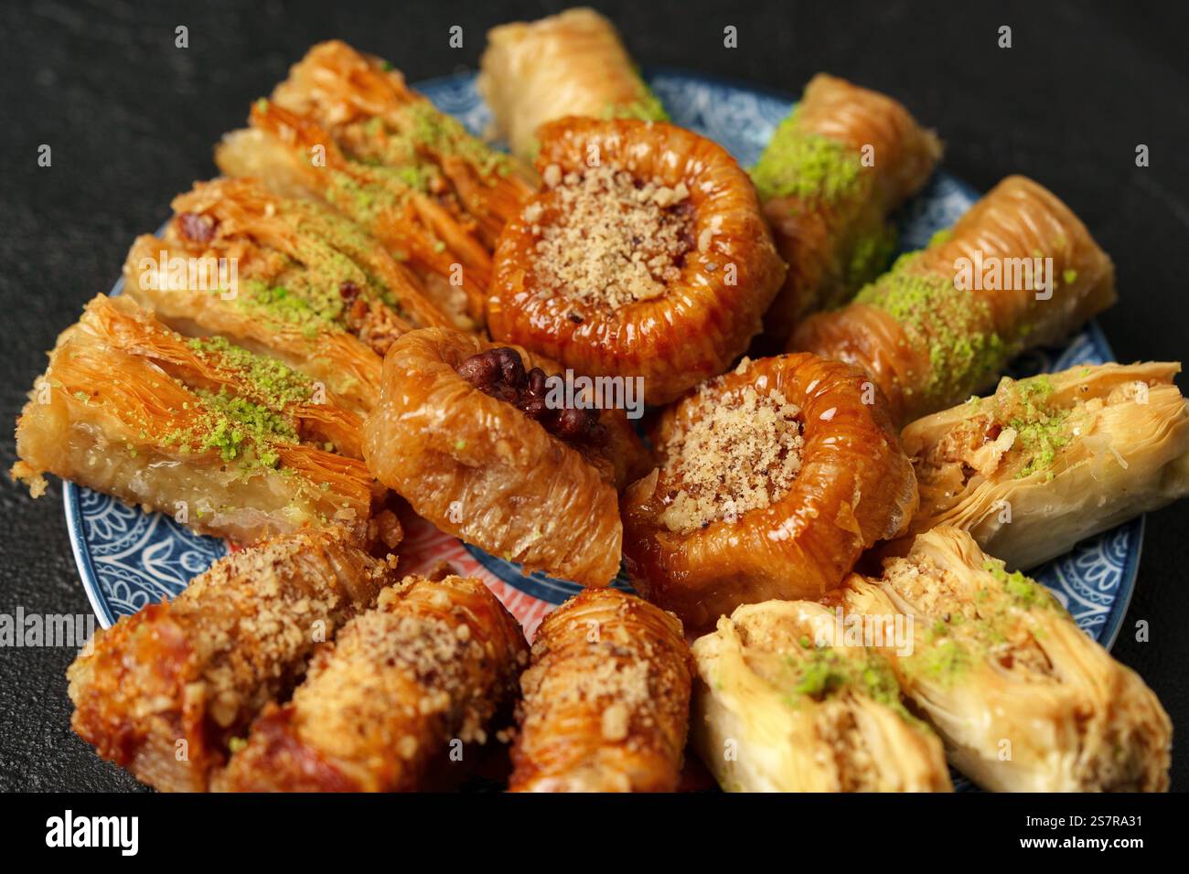 Assorted traditional pastries on a blue decorative plate in a cozy ...