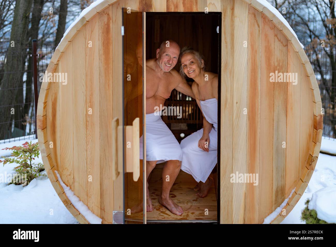 Senior couple using small sauna during cold winter day. Spa weekend ...