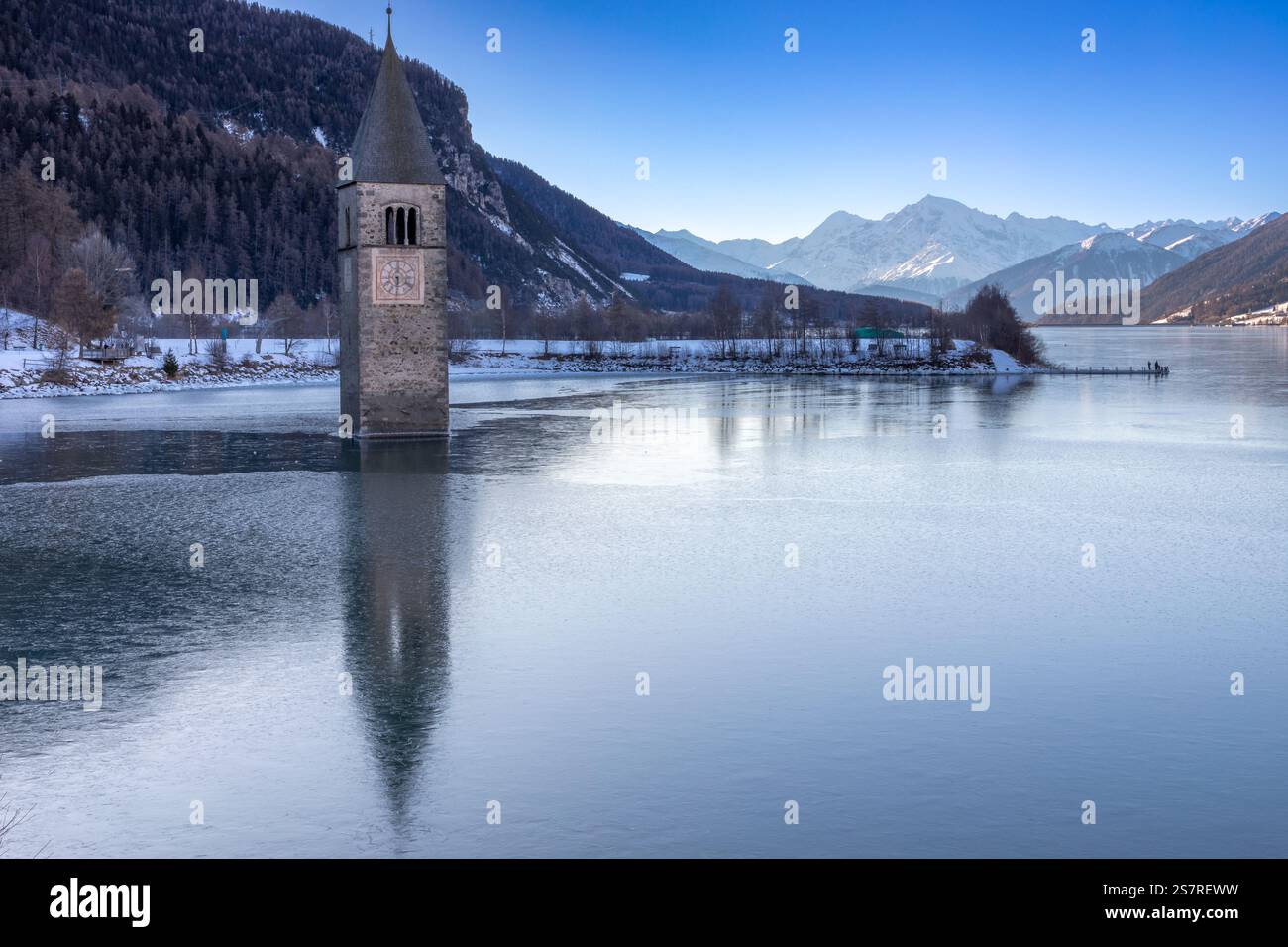 Steeple of Old Curon in frozen lake Reschensee, South Tyrol, Italy ...