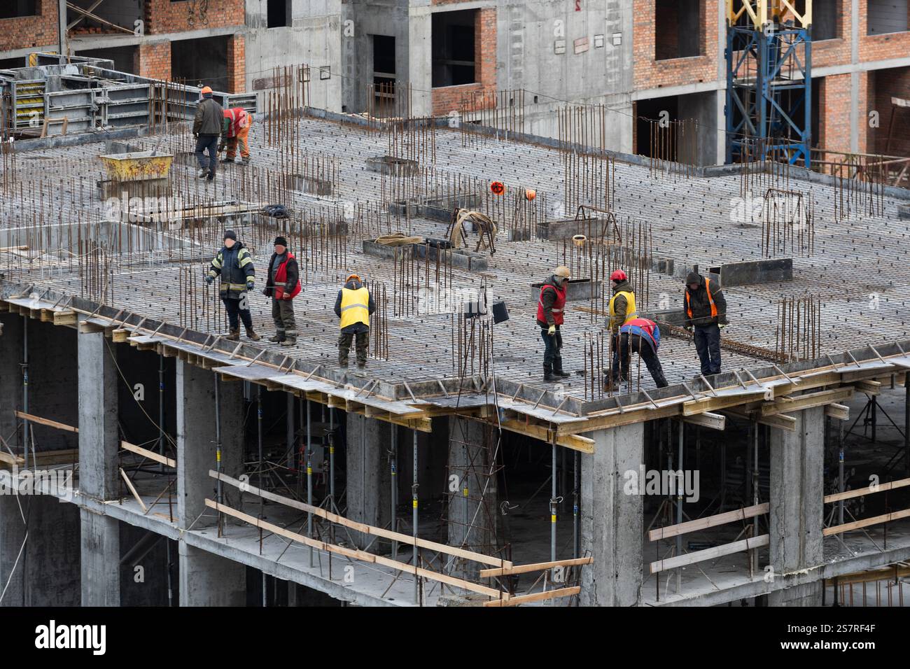 concreting work: construction site worker during concrete pouring into ...