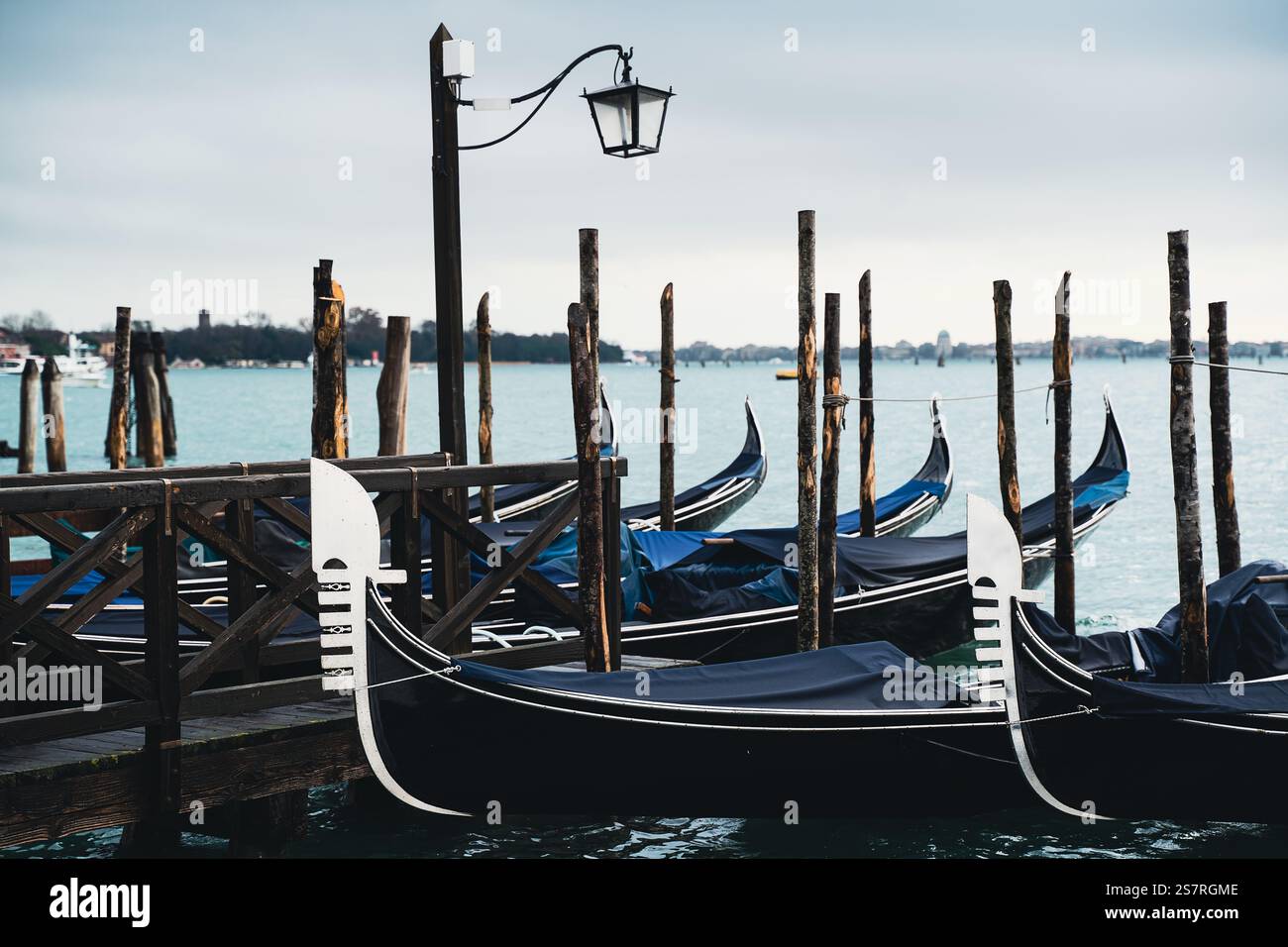 Classic gondolas floating near a rustic wooden dock in a Venetian canal ...