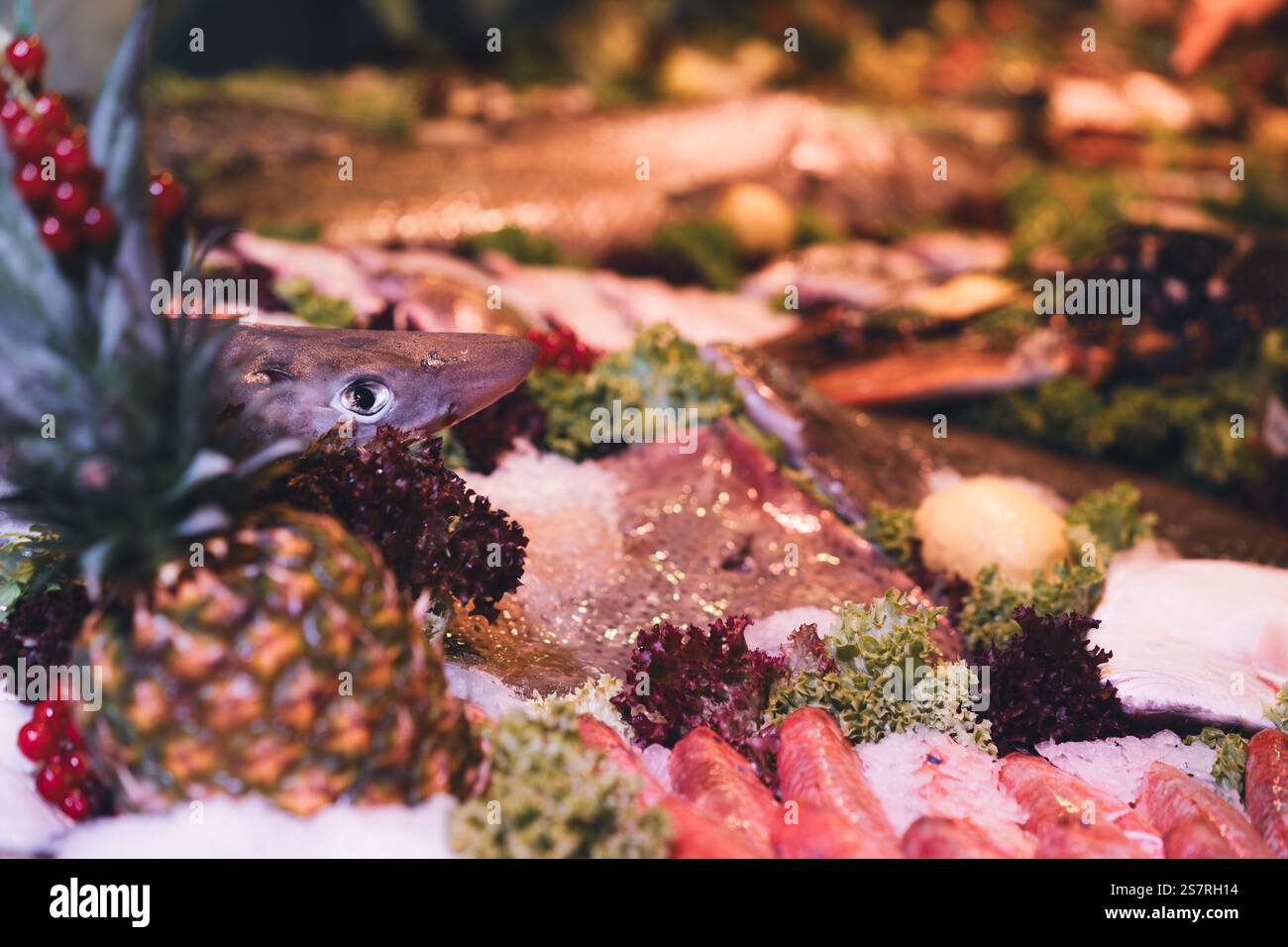 A selection of fresh fish displayed with vegetables and fruits at a ...