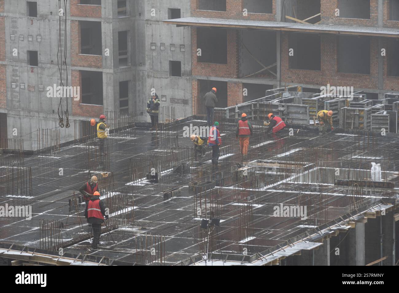 concreting work: construction site worker during concrete pouring into ...